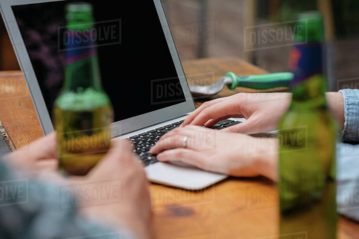 Cropped view of couple drinking beer using laptop - Royalty-free Stock ...