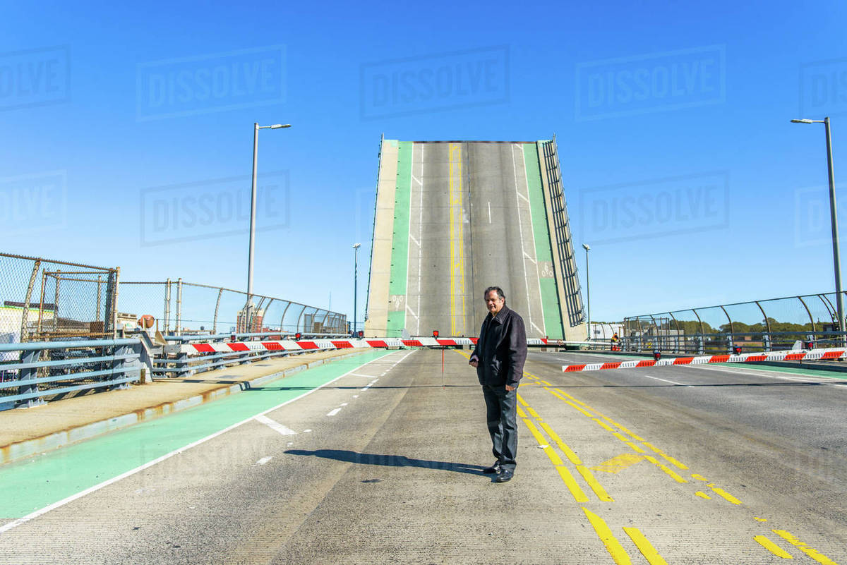 Portrait of worker in front of barrier and drawbridge at biofuel plant ...