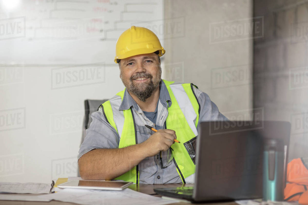 Construction worker using laptop at desk - Royalty-free Stock Photo ...
