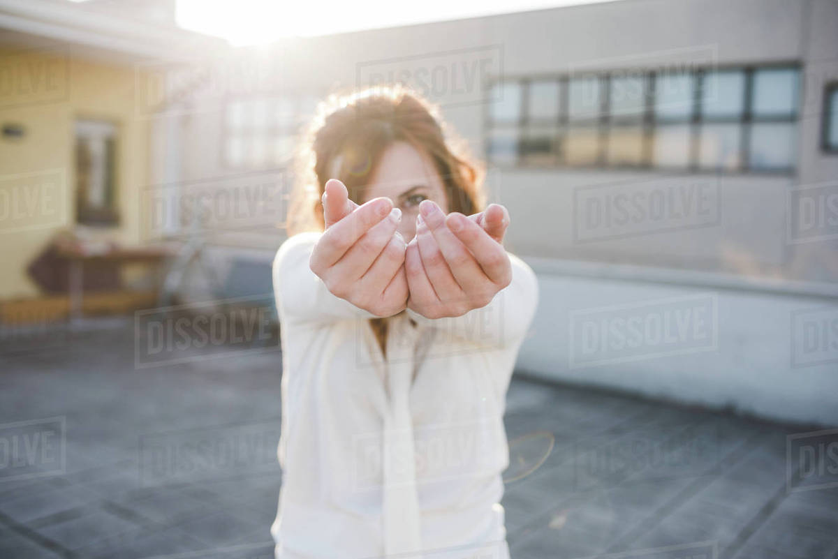 Portrait of beautiful young woman dancing with hands reaching out on ...