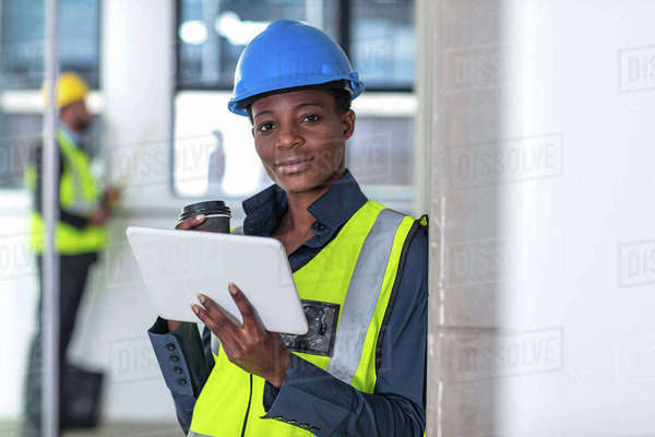 Woman with hard hat and hi viz jacket using digital tablet - Royalty ...