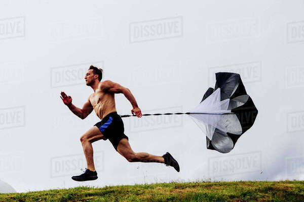 Man running, using running parachute - Royalty-free Stock Photo | Dissolve