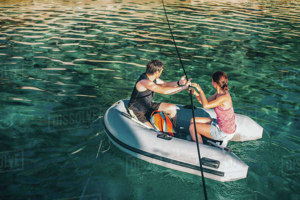 Couple working tow line in dinghy - Stock Photo - Dissolve