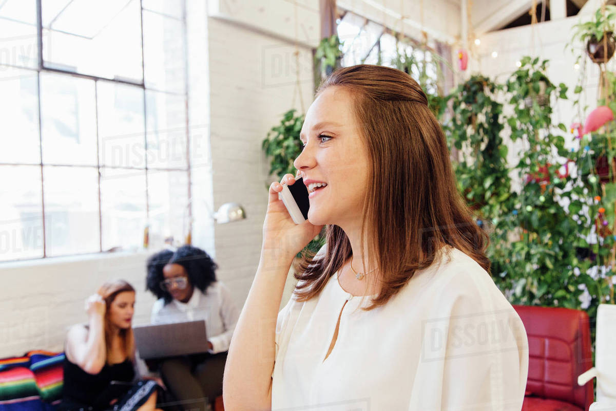 Woman in office making telephone call on smartphone - Royalty-free ...