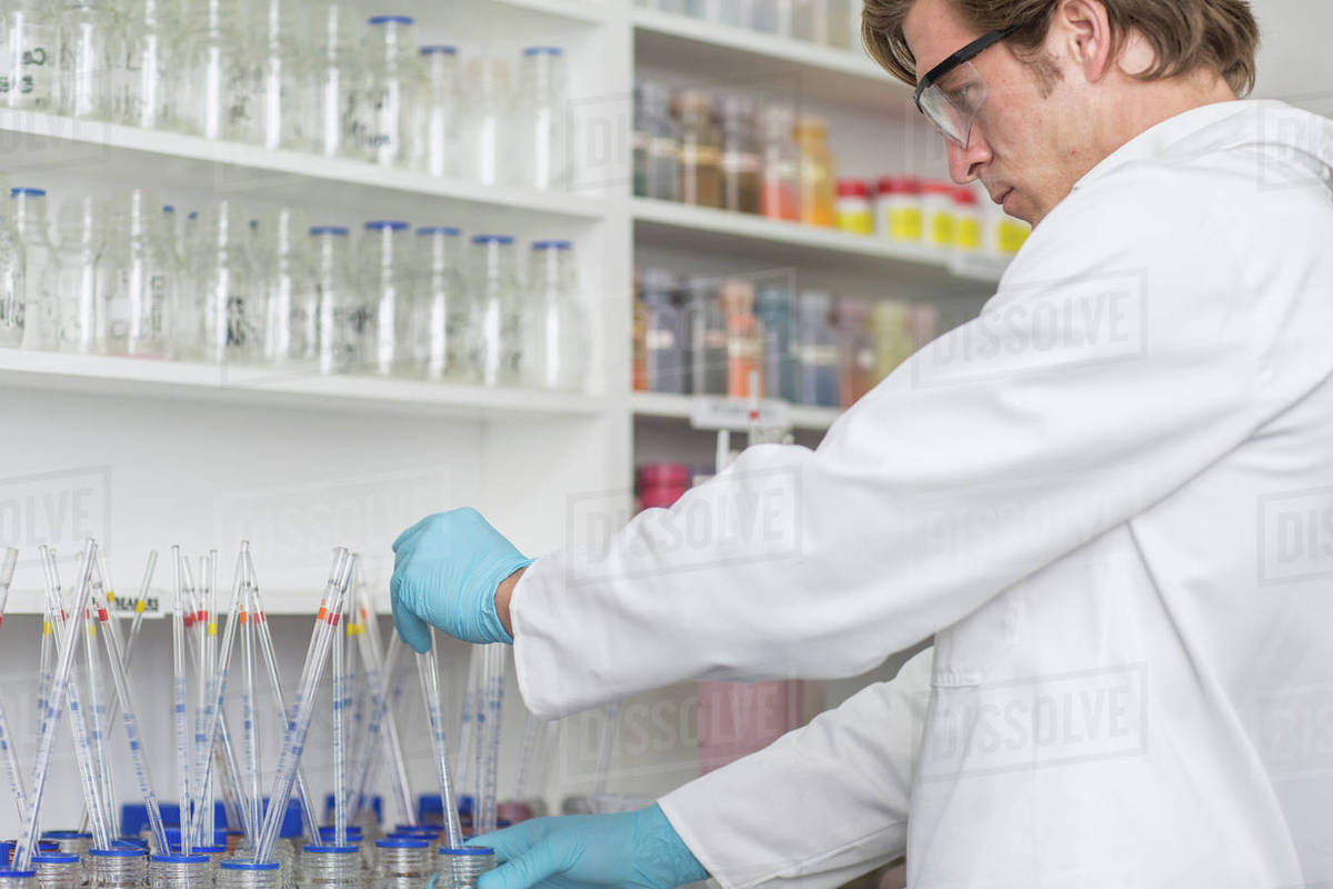 Lab worker taking dye from beaker using long pipette - Royalty-free ...