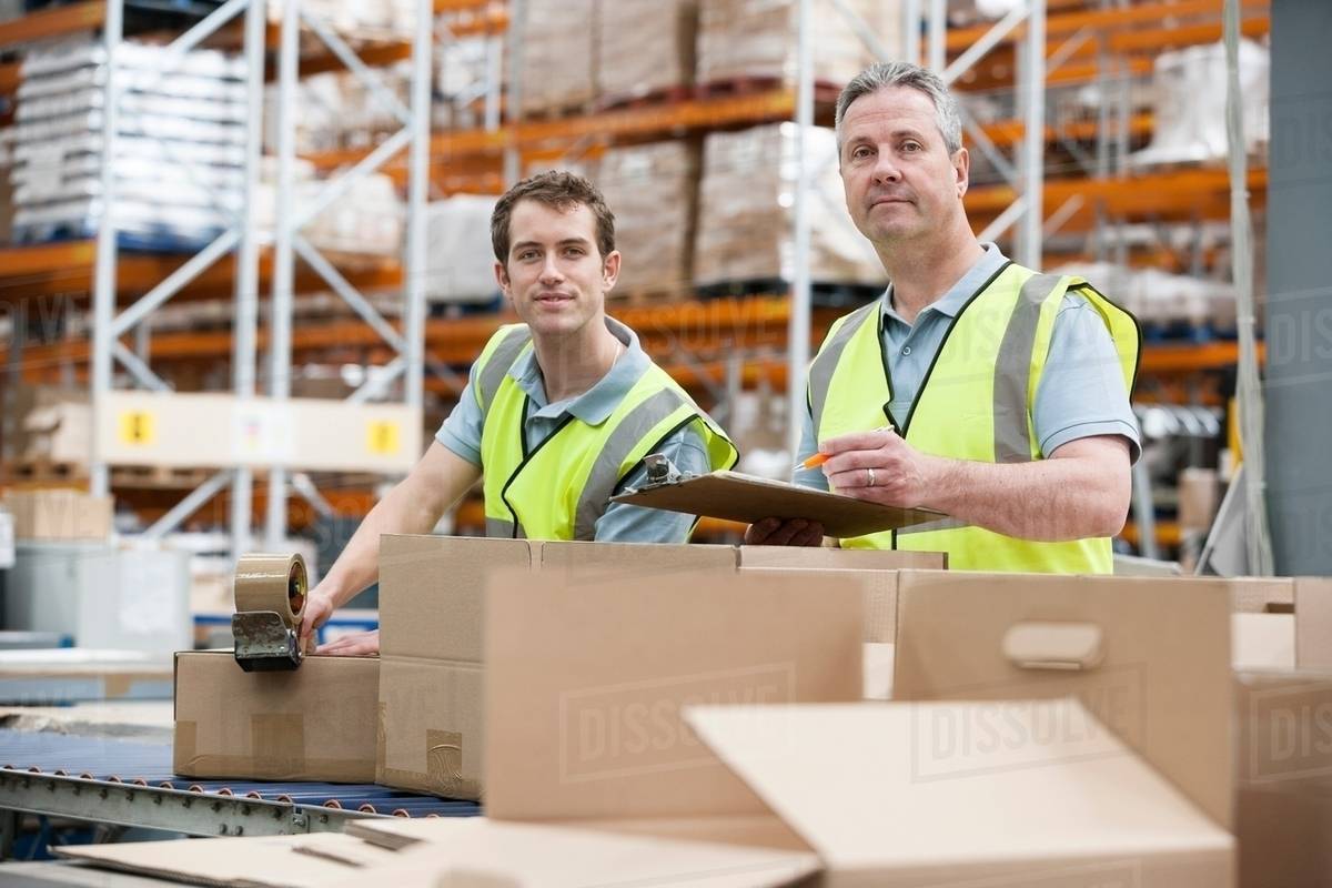 Two men checking stock in warehouse - Royalty-free Stock Photo | Dissolve