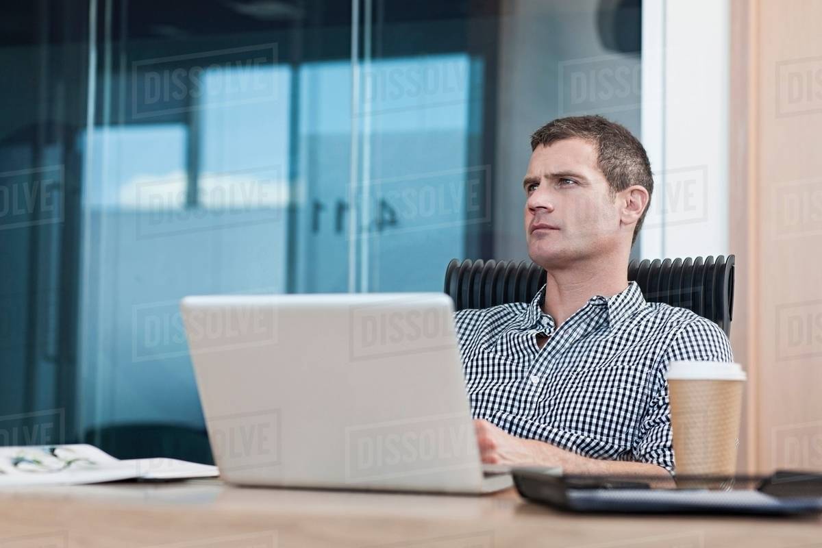Man with laptop, looking away - Stock Photo - Dissolve