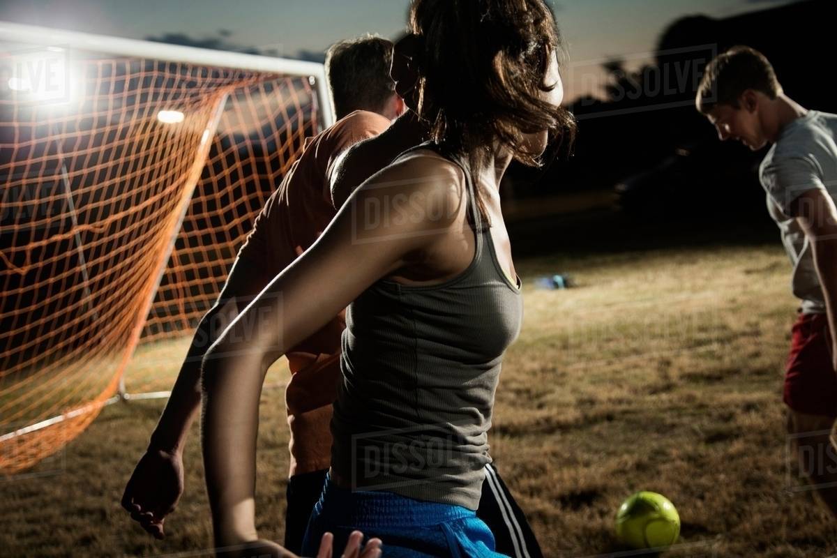 Friends playing soccer at night - Royalty-free Stock Photo | Dissolve