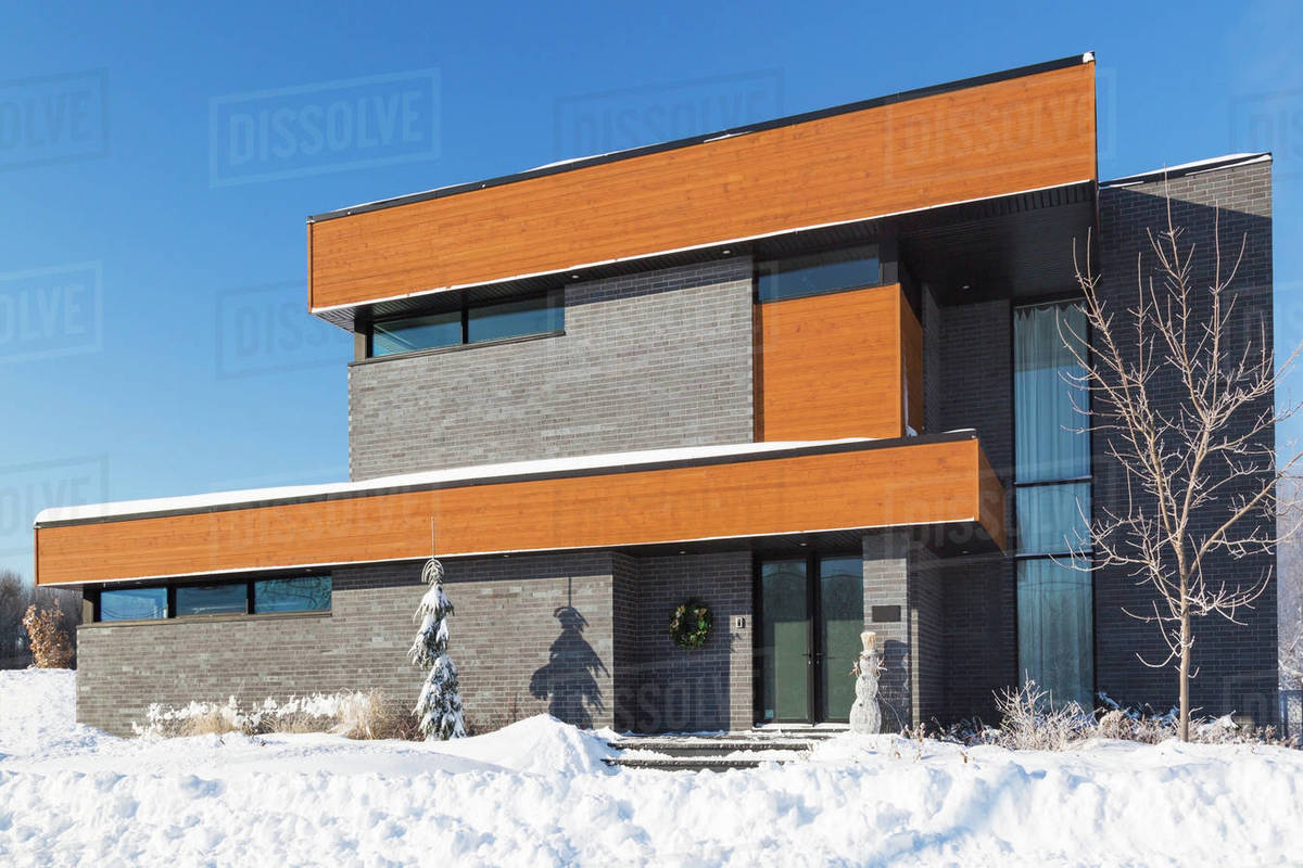 Modern grey brick and stained wood finish cube style house facade in ...