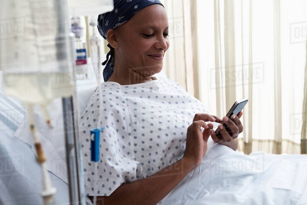 Female hospital patient using cellphone - Stock Photo - Dissolve