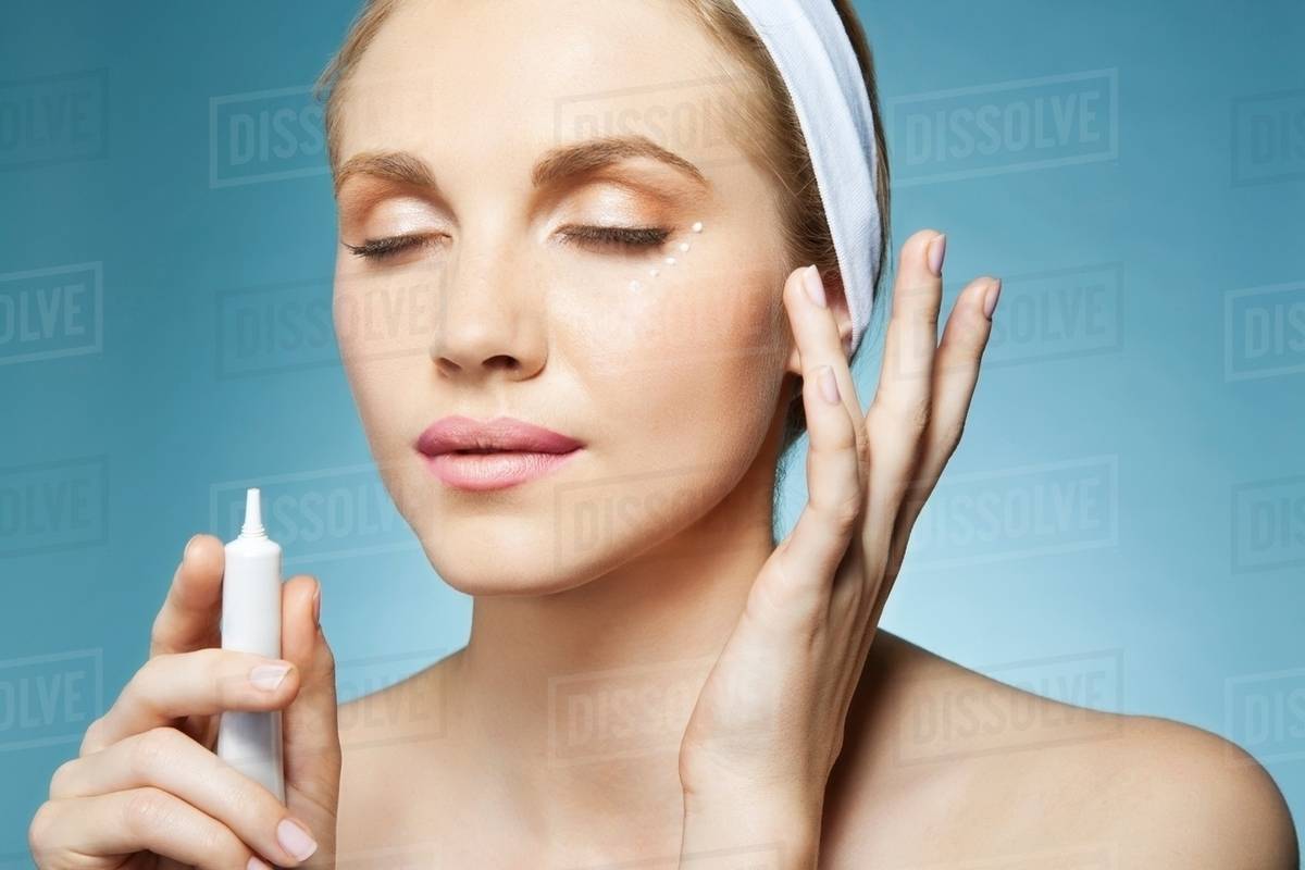 Woman applying eye cream - Royalty-free Stock Photo | Dissolve