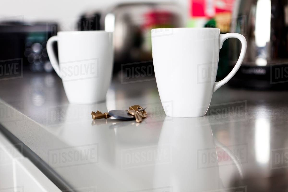 Two coffee mugs with keys on kitchen counter - Royalty-free Stock Photo ...