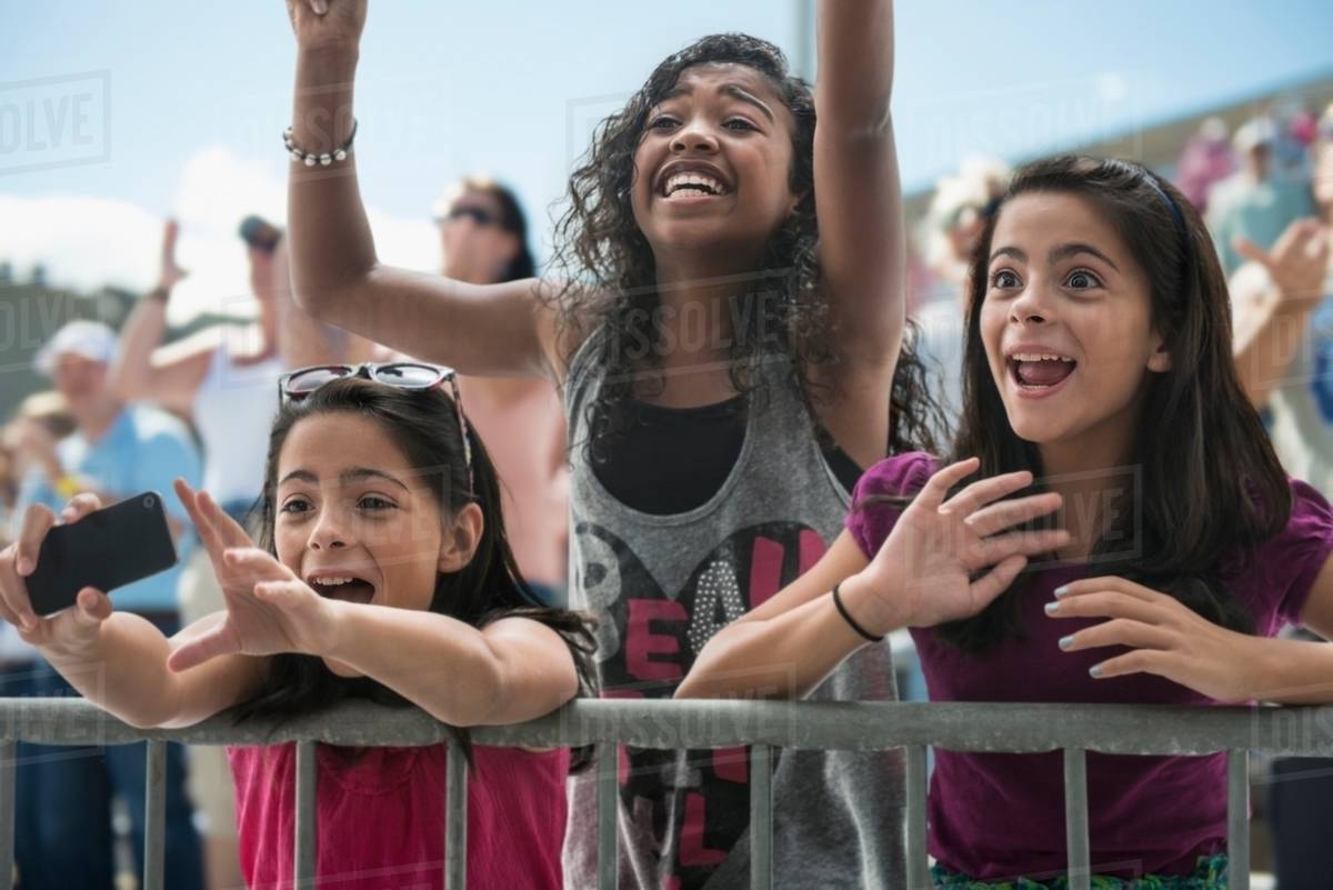 Three excited girls at a pop concert - Royalty-free Stock Photo | Dissolve