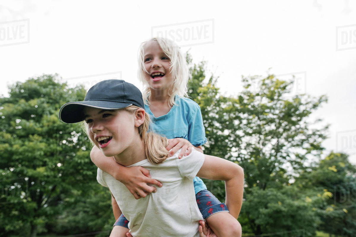Children playing piggyback in park - Royalty-free Stock Photo | Dissolve