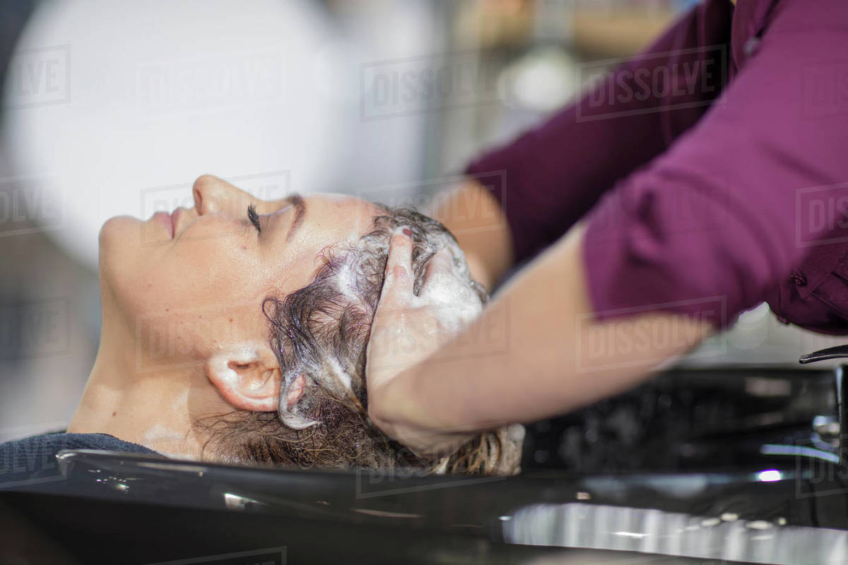 Hairdresser shampooing customer's hair in salon - Stock Photo - Dissolve