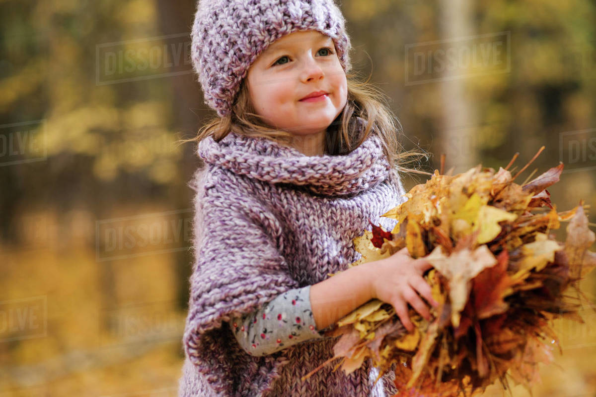 Little girl with handful of autumn leaves - Stock Photo - Dissolve