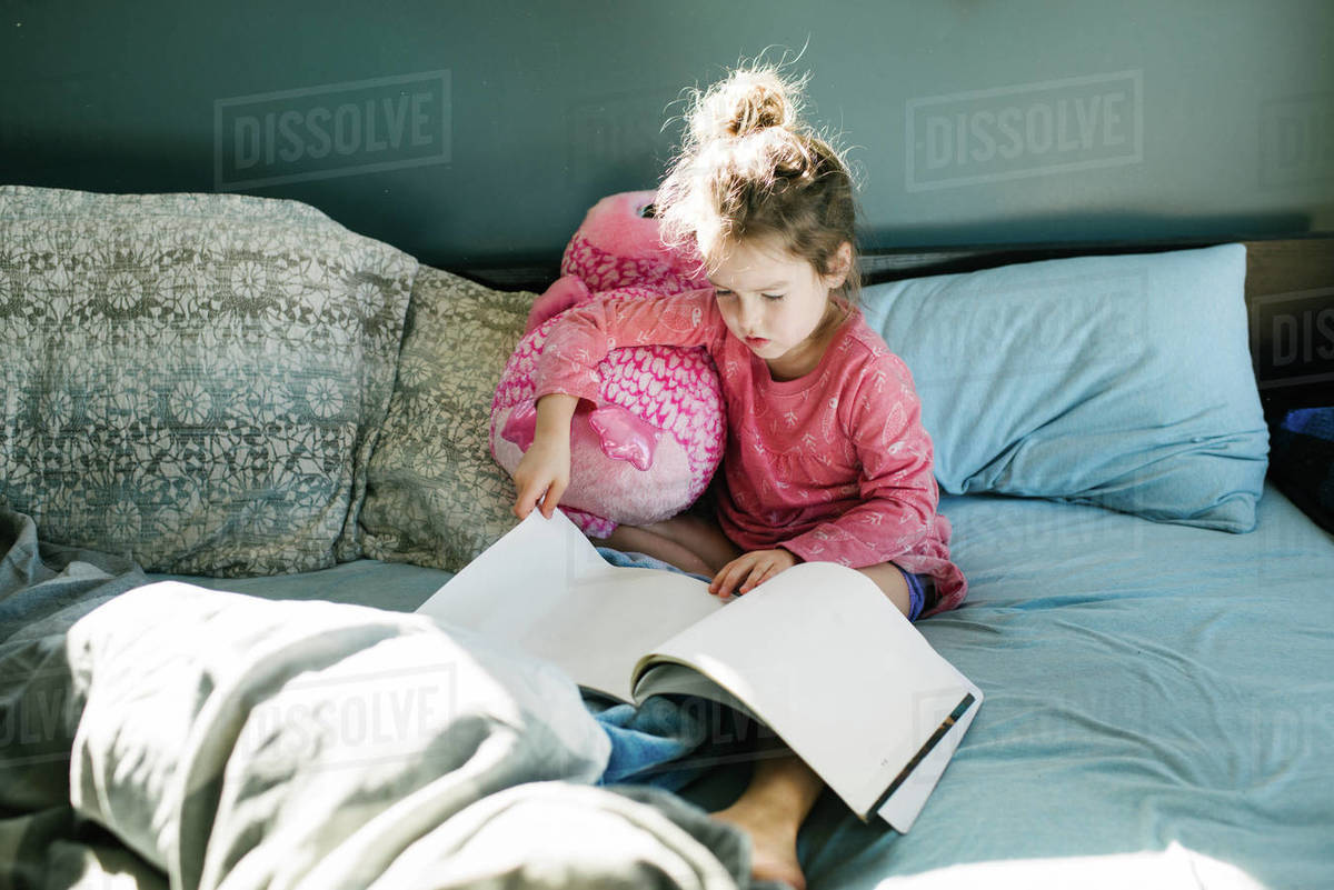 Little girl reading in bed - Royalty-free Stock Photo | Dissolve