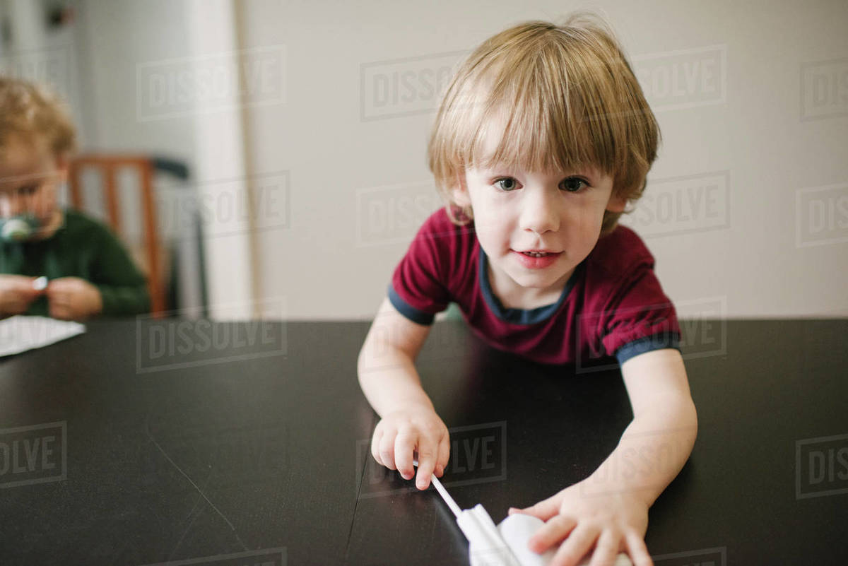 Boy playing at table - Stock Photo - Dissolve