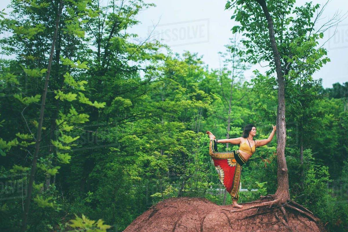Woman doing dancer pose in forest - Royalty-free Stock Photo | Dissolve