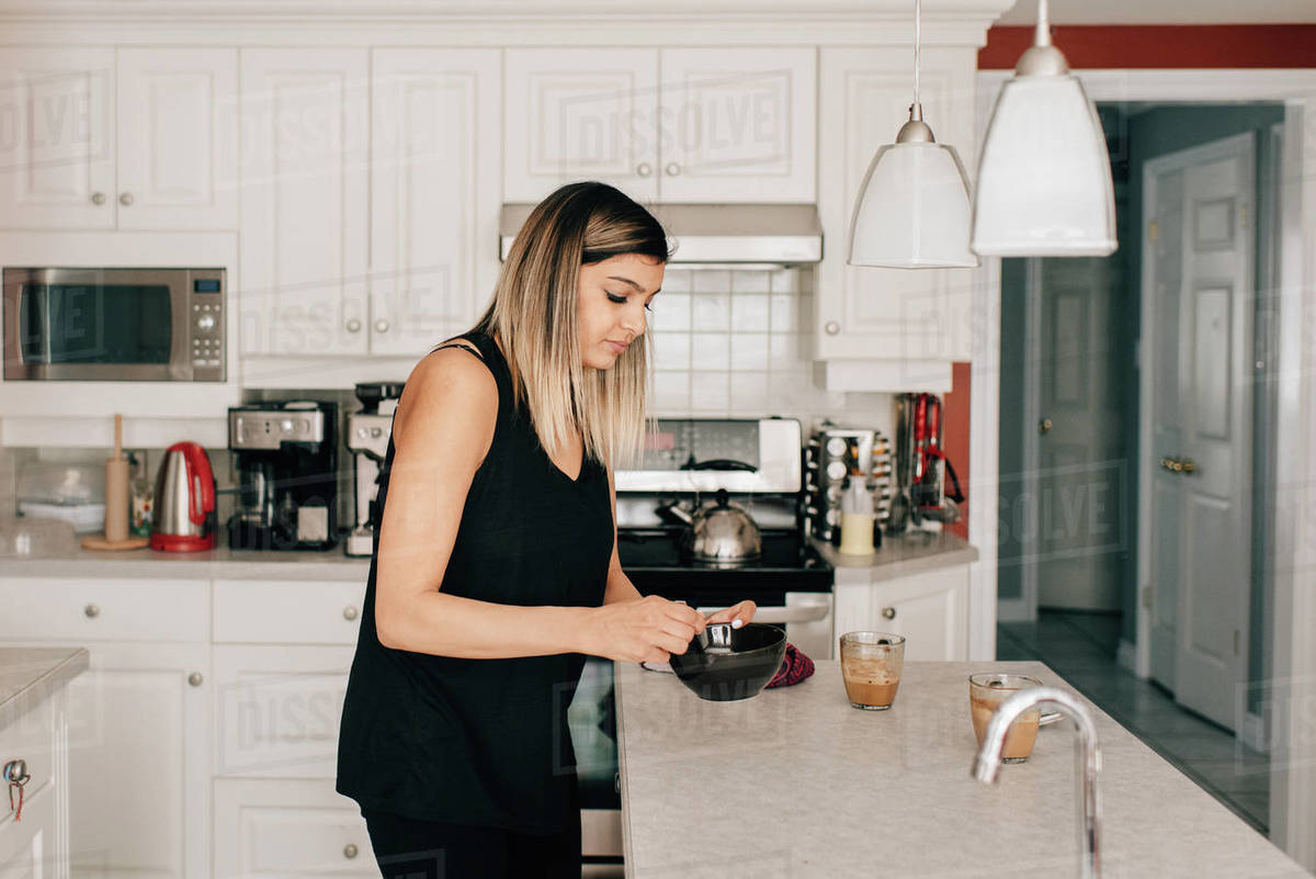 Mid adult woman at kitchen counter with cereal bowl - Royalty-free ...