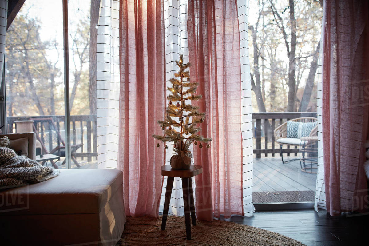 Decorated Christmas tree in living room, verandah in background - Stock ...