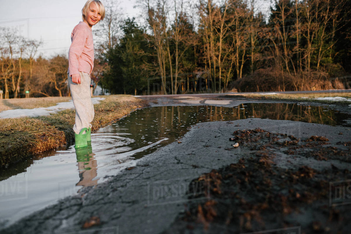 Boy ankle deep in rural puddle, portrait - Royalty-free Stock Photo ...