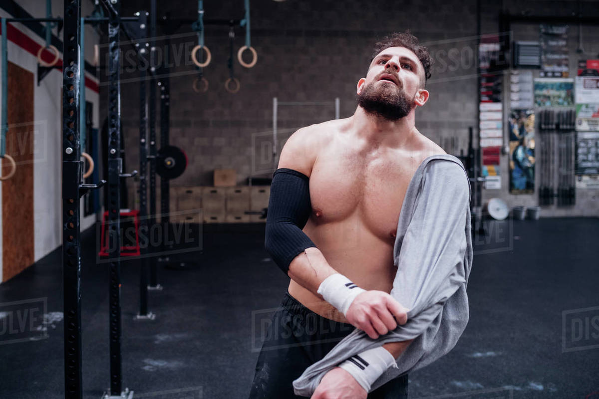 Exhausted young man taking break in gym - Royalty-free Stock Photo ...