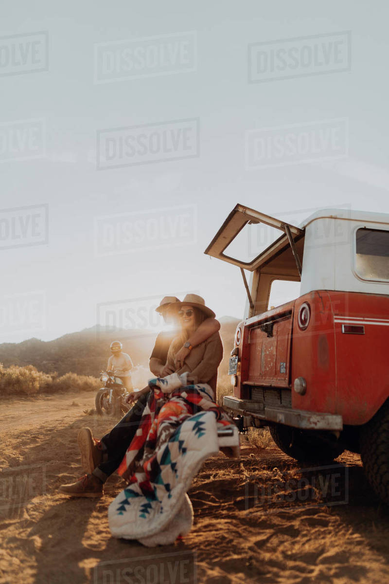 Couple sitting outside off road vehicle, Kennedy Meadows, California ...