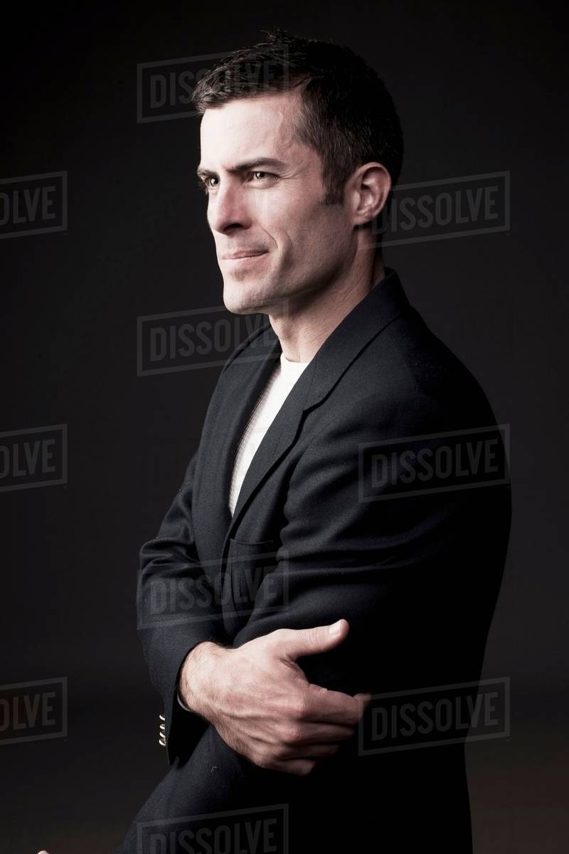 Serious man holding his arm - Royalty-free Stock Photo | Dissolve