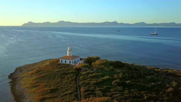 AERIAL WS Alcanada Lighthouse in sunlight, Bay of Alcudia, Alcudia ...