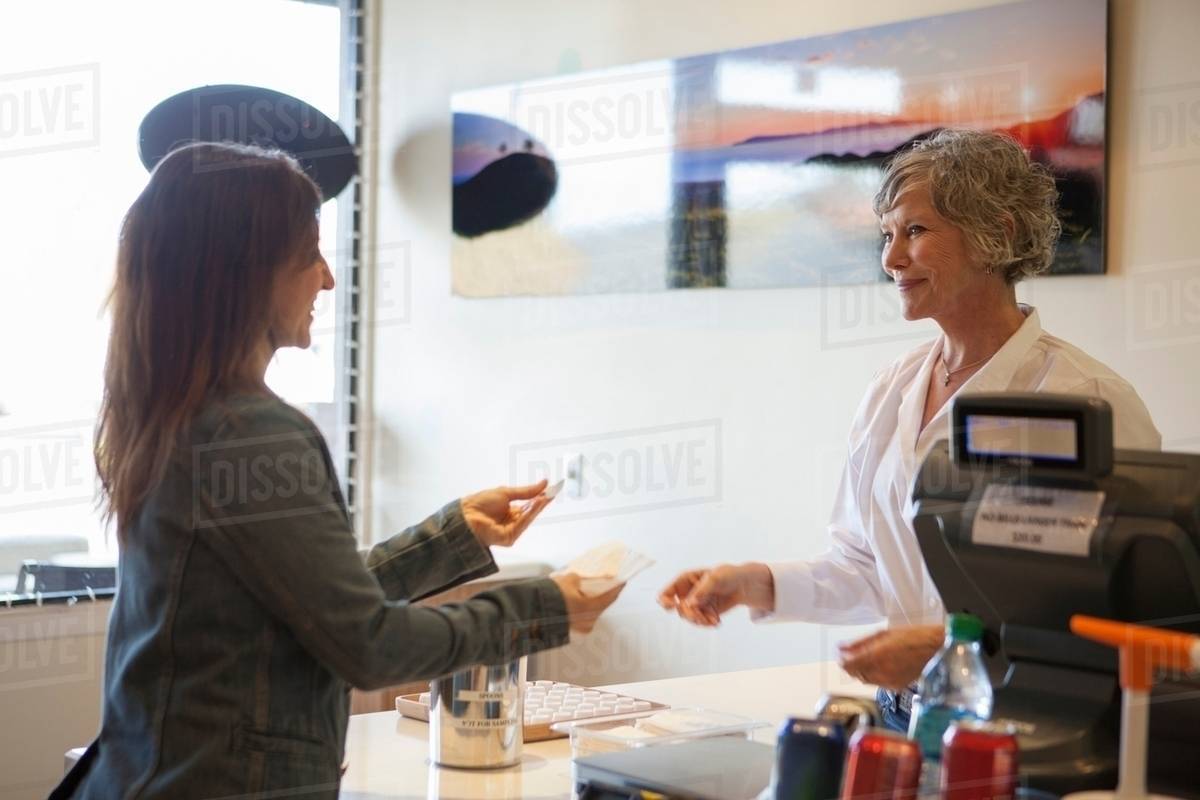 Cashier talking to customer in store - Stock Photo - Dissolve