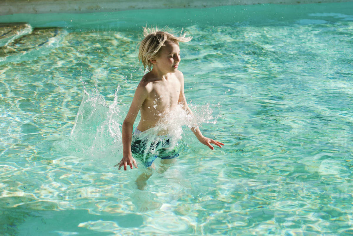 Boy jumping into swimming pool - Royalty-free Stock Photo | Dissolve