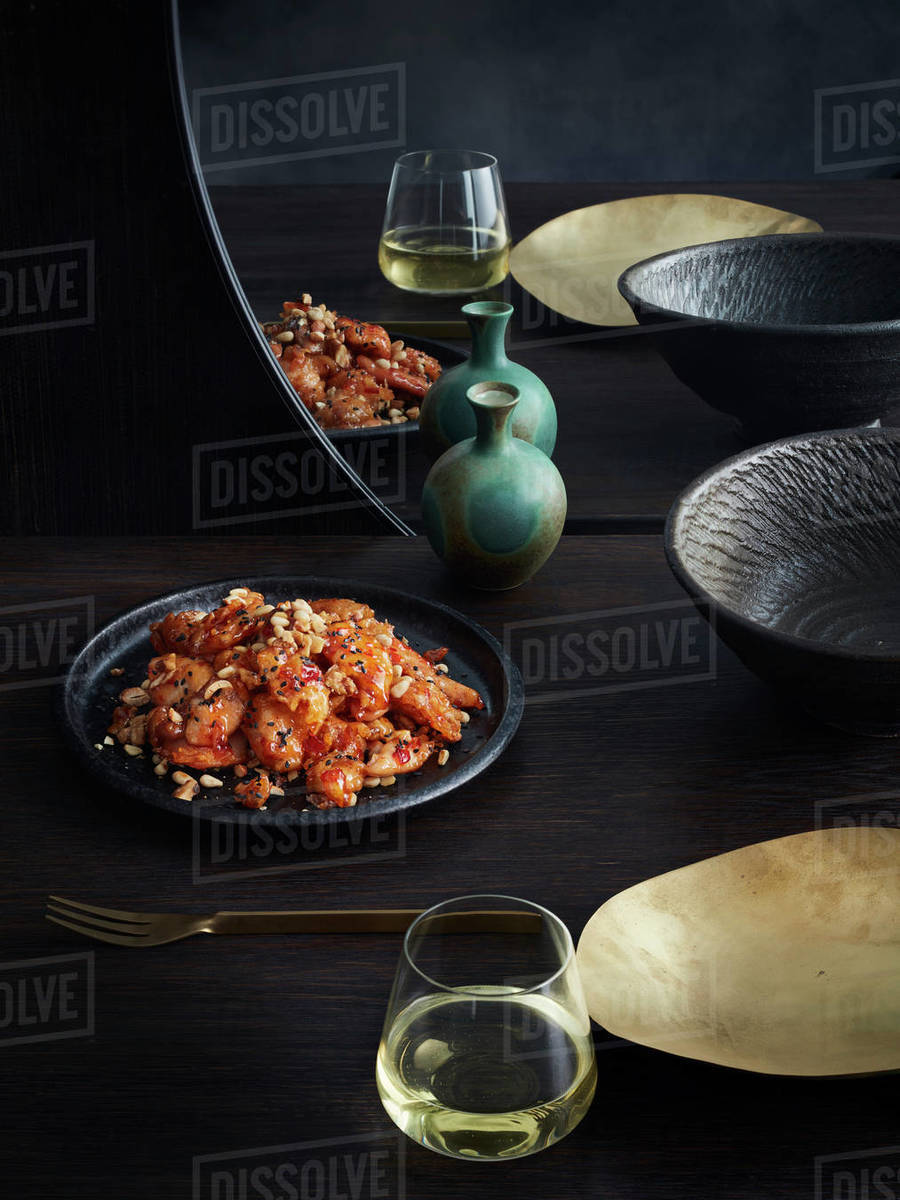 Rustic low key still life with plate of chilli plum fried chicken and ...