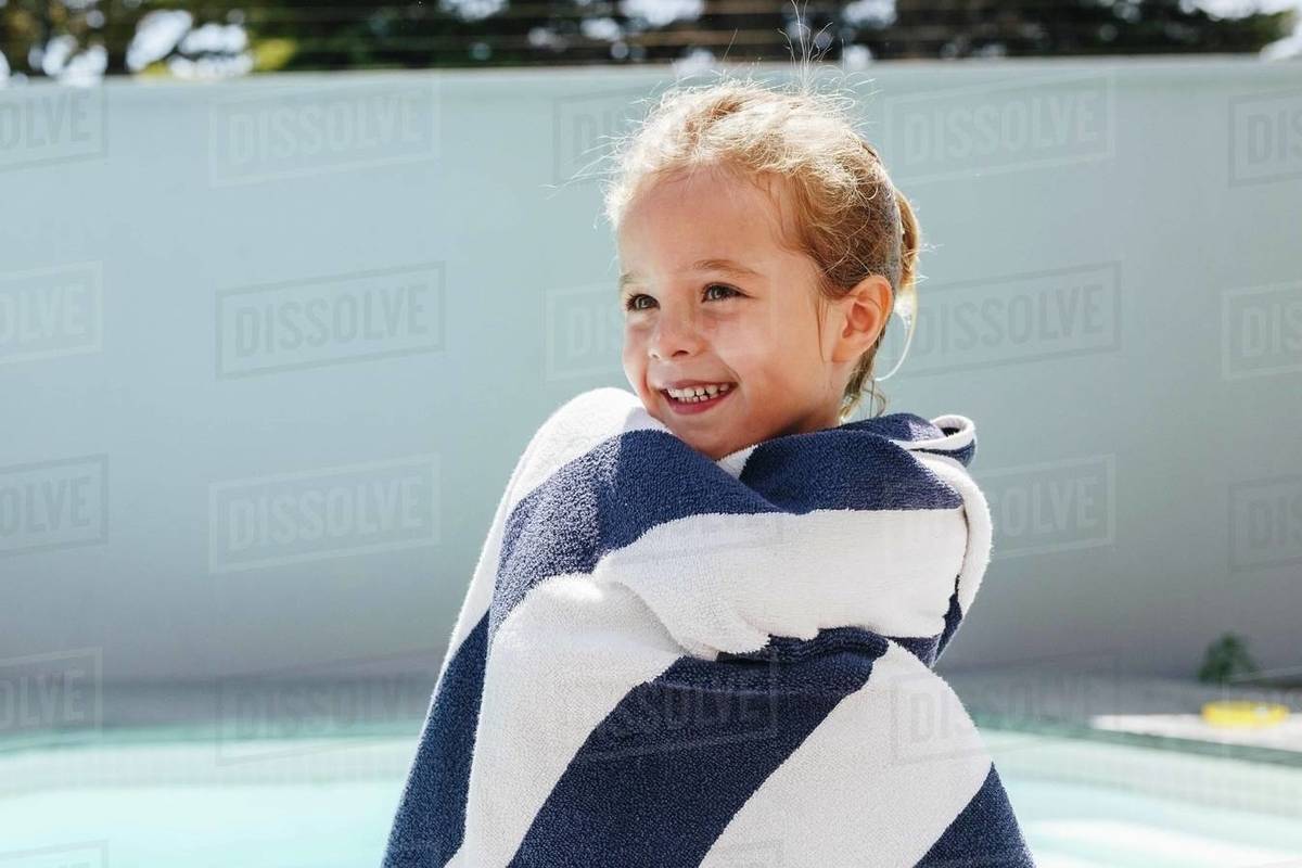 Happy little girl wrapped in towel by swimming pool - Royalty-free ...