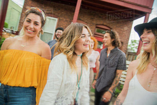 Group of friends laughing and chatting at community garden party ...