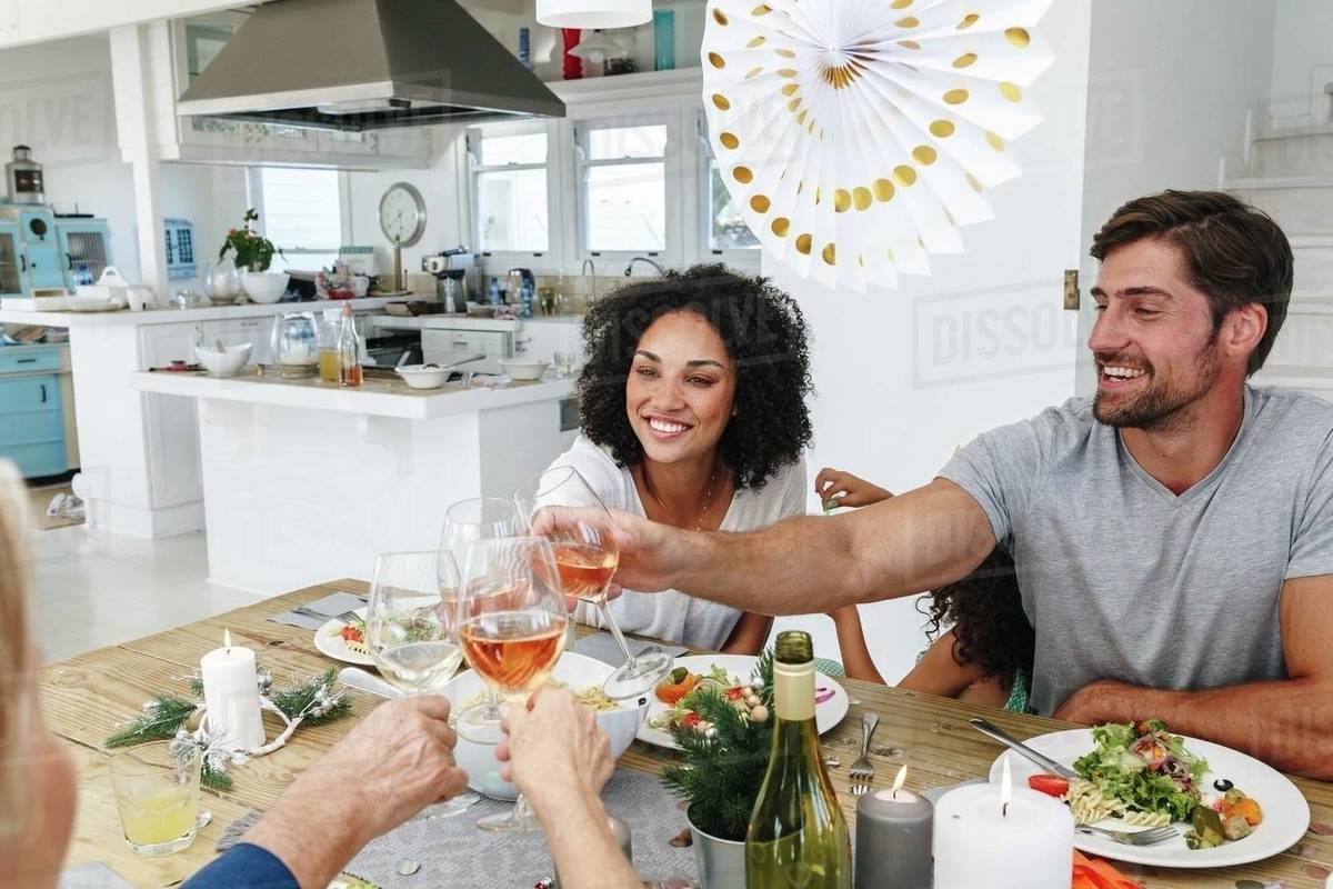 Family toasting wine at dining table in home party - Royalty-free Stock ...