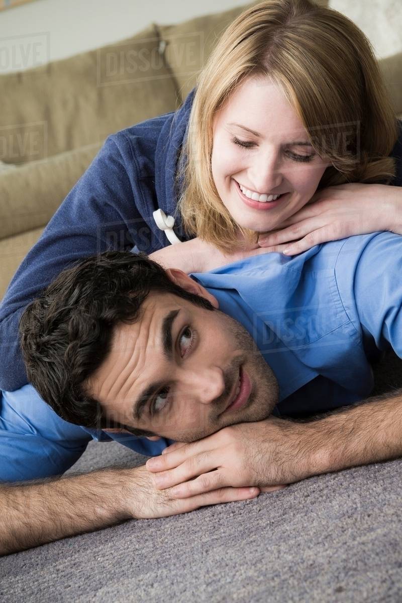 Young couple lying on floor, woman on top of man - Royalty-free Stock ...