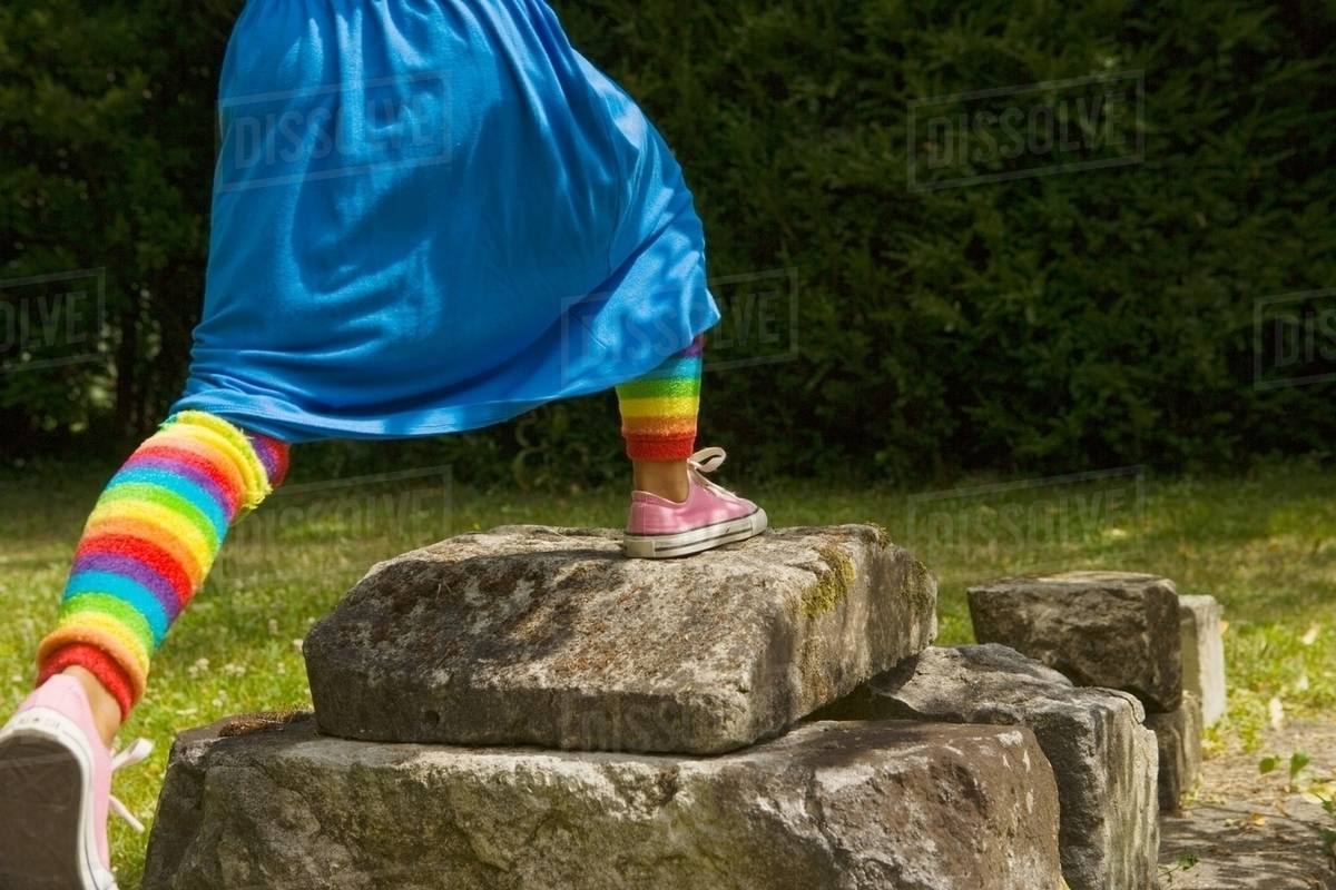 A girl stepping on rocks - Stock Photo - Dissolve