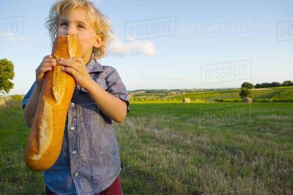 A boy eating a baguette - Royalty-free Stock Photo | Dissolve