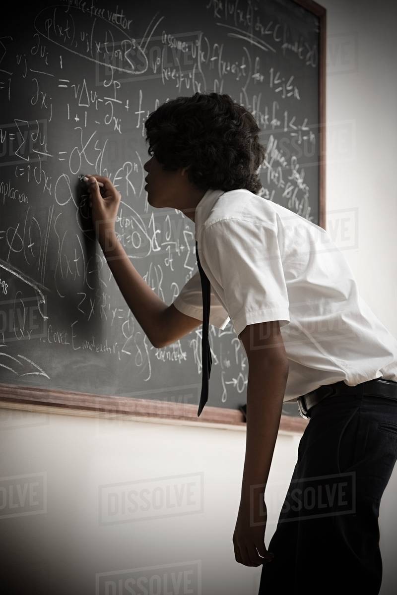 Boy writing on blackboard - Stock Photo - Dissolve