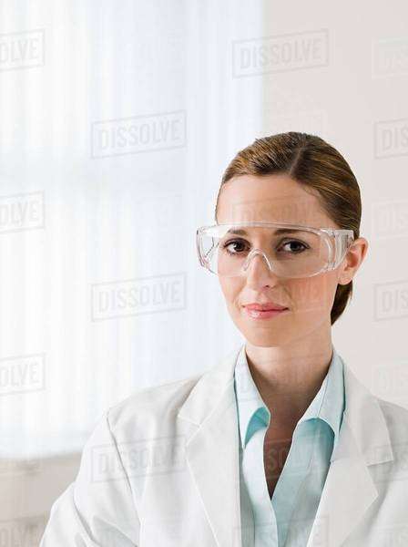 Female scientist wearing safety goggles - Stock Photo - Dissolve