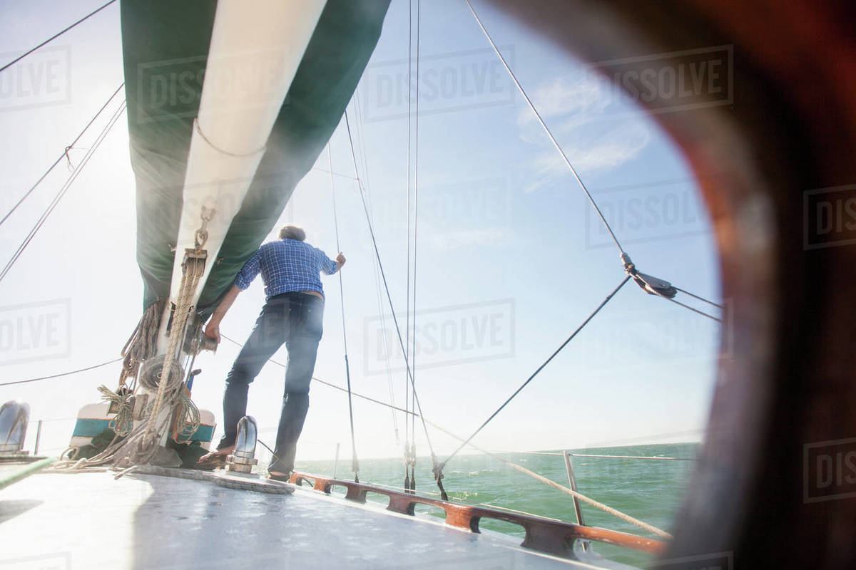 Man standing on deck of yacht - Stock Photo - Dissolve
