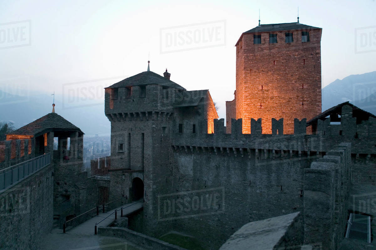 Entrance and drawbridge of Bellinzona city wall illuminated at night ...