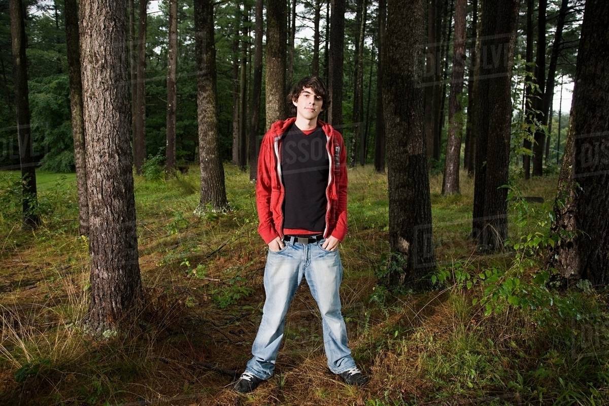 Young man standing in forest - Royalty-free Stock Photo | Dissolve