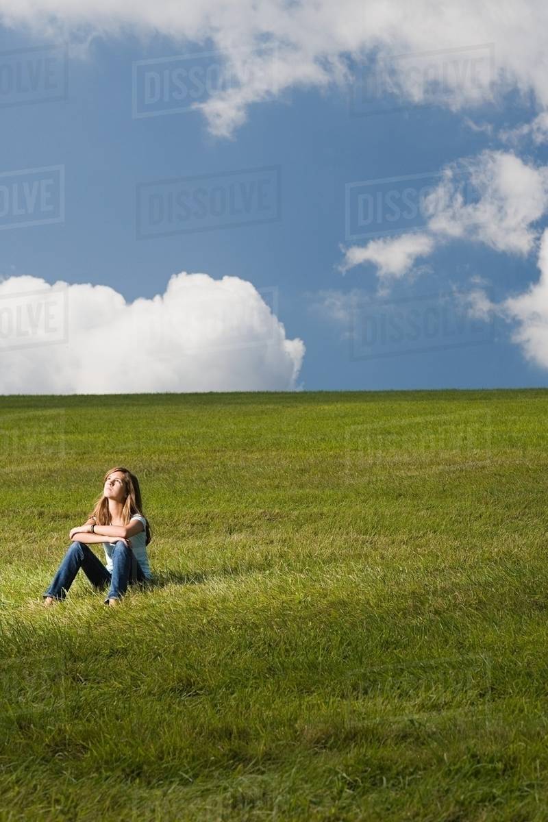 Girl sitting in a field - Royalty-free Stock Photo | Dissolve