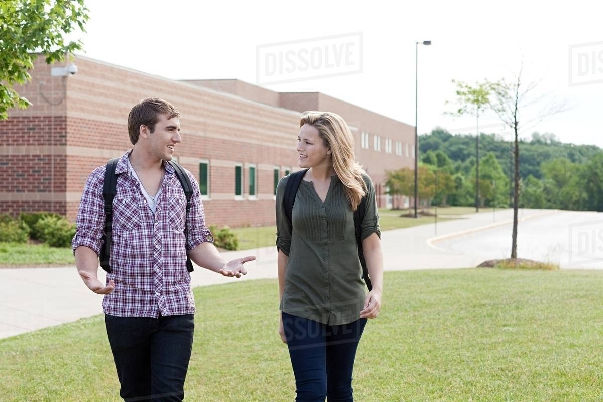 High school students walking by school - Stock Photo - Dissolve