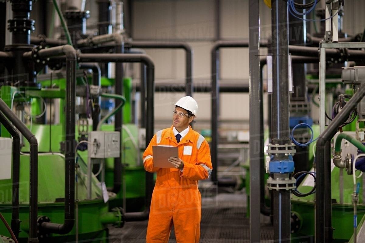 Engineer inspecting machinery in factory - Royalty-free Stock Photo ...