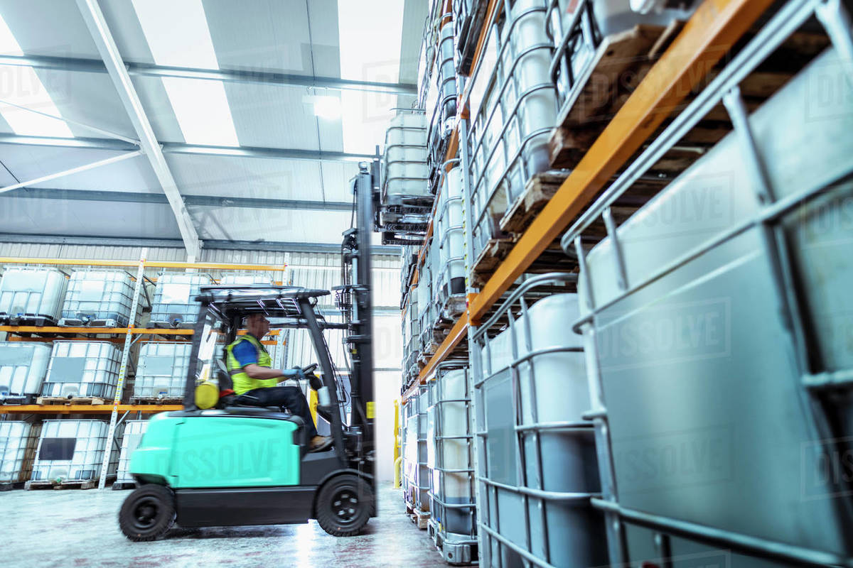 Forklift moving Intermediate Bulk Containers in oil plant - Stock Photo ...