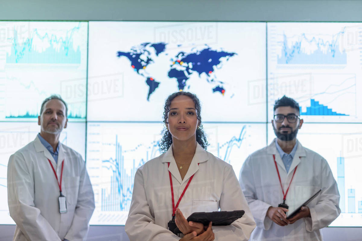 Portrait of researchers with digital tablets at interactive screens ...
