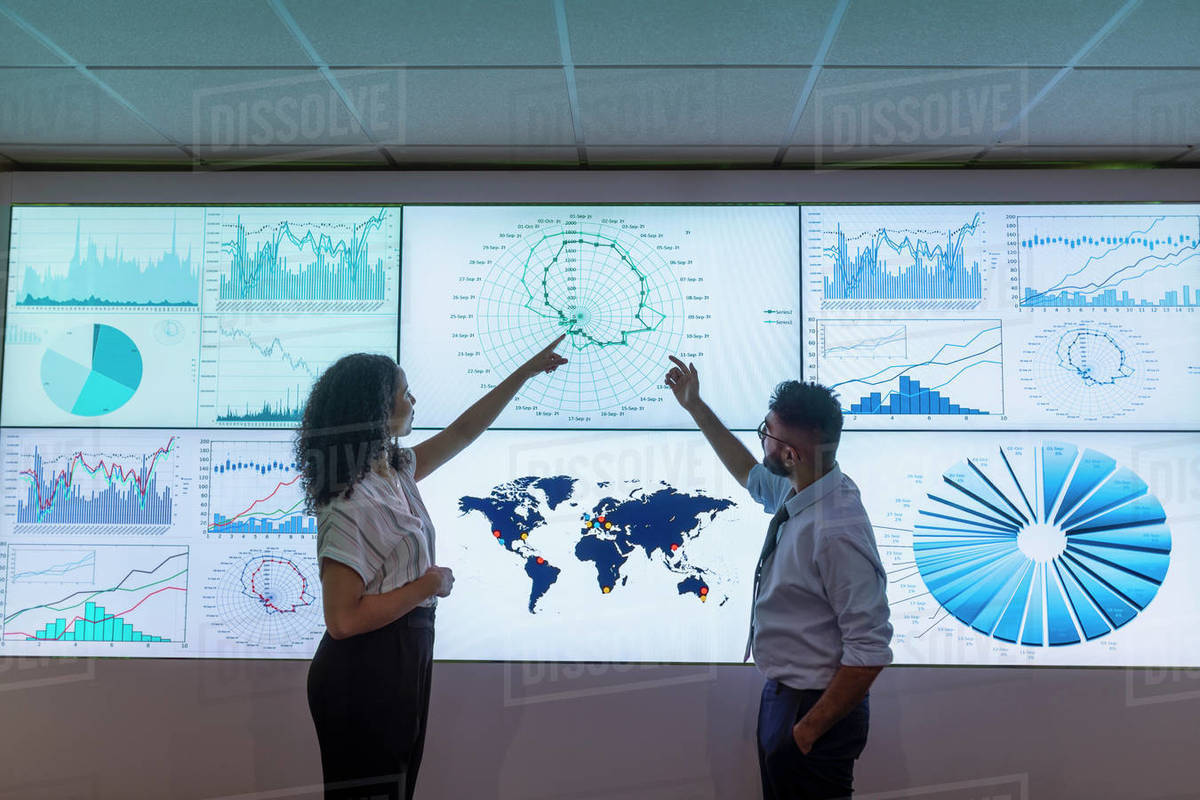 Business people discussing charts on interactive screens - Stock Photo ...